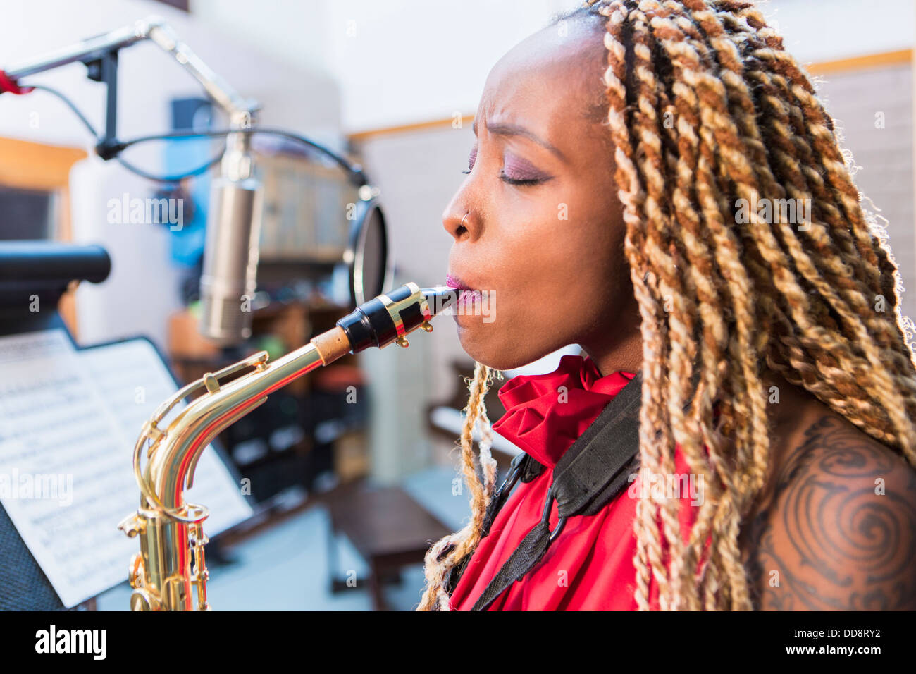 African American saxophone player recording in studio Stock Photo - Alamy