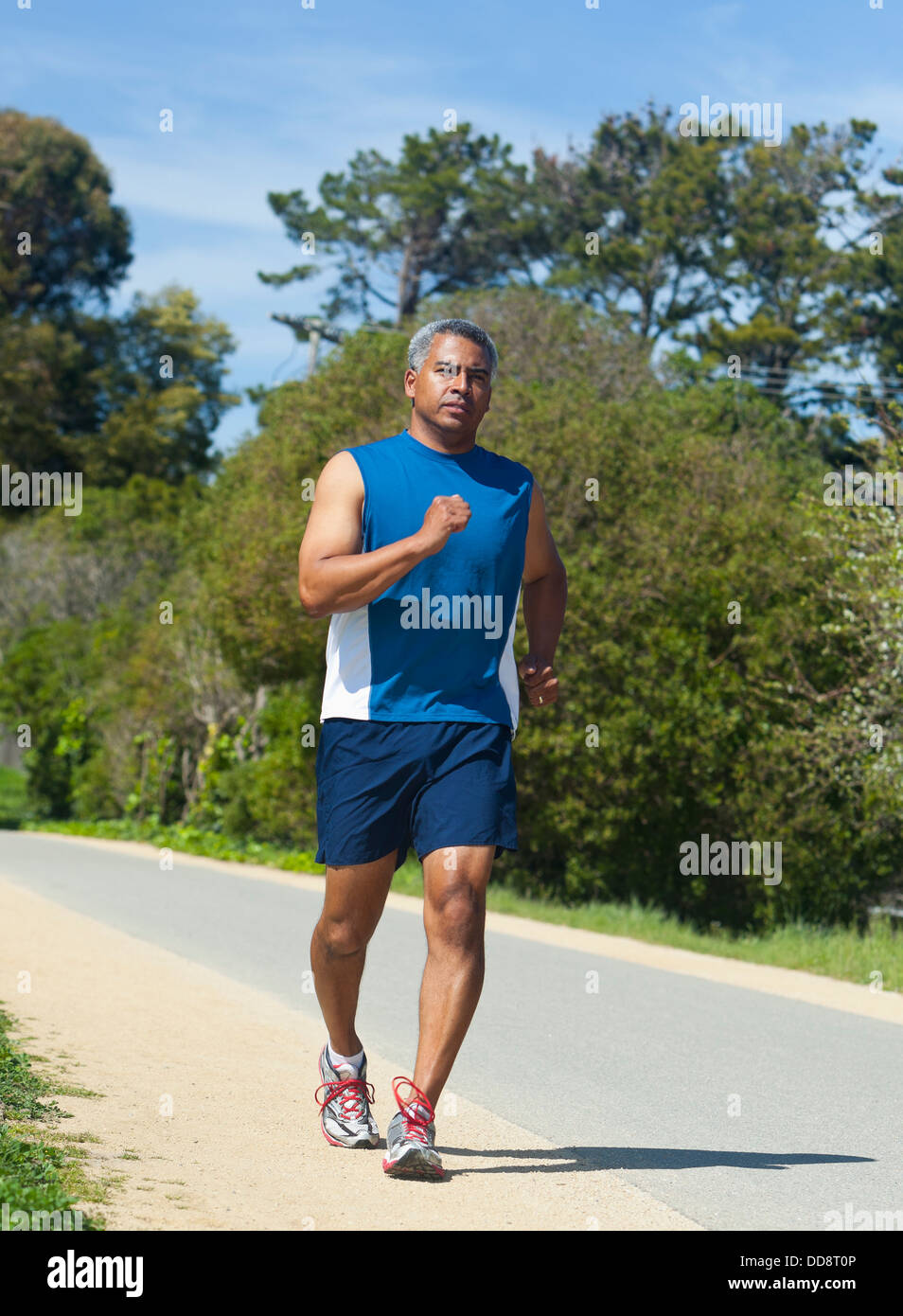 Mixed race man running on rural road Stock Photo - Alamy