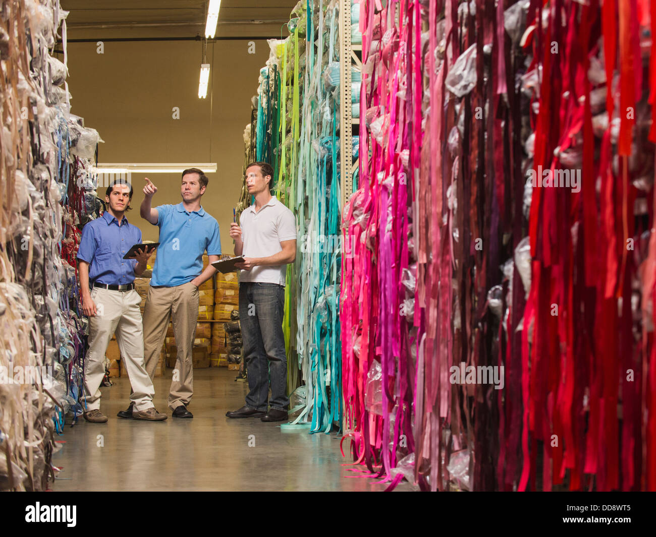 Workers examining fabric in textile factory Stock Photo - Alamy