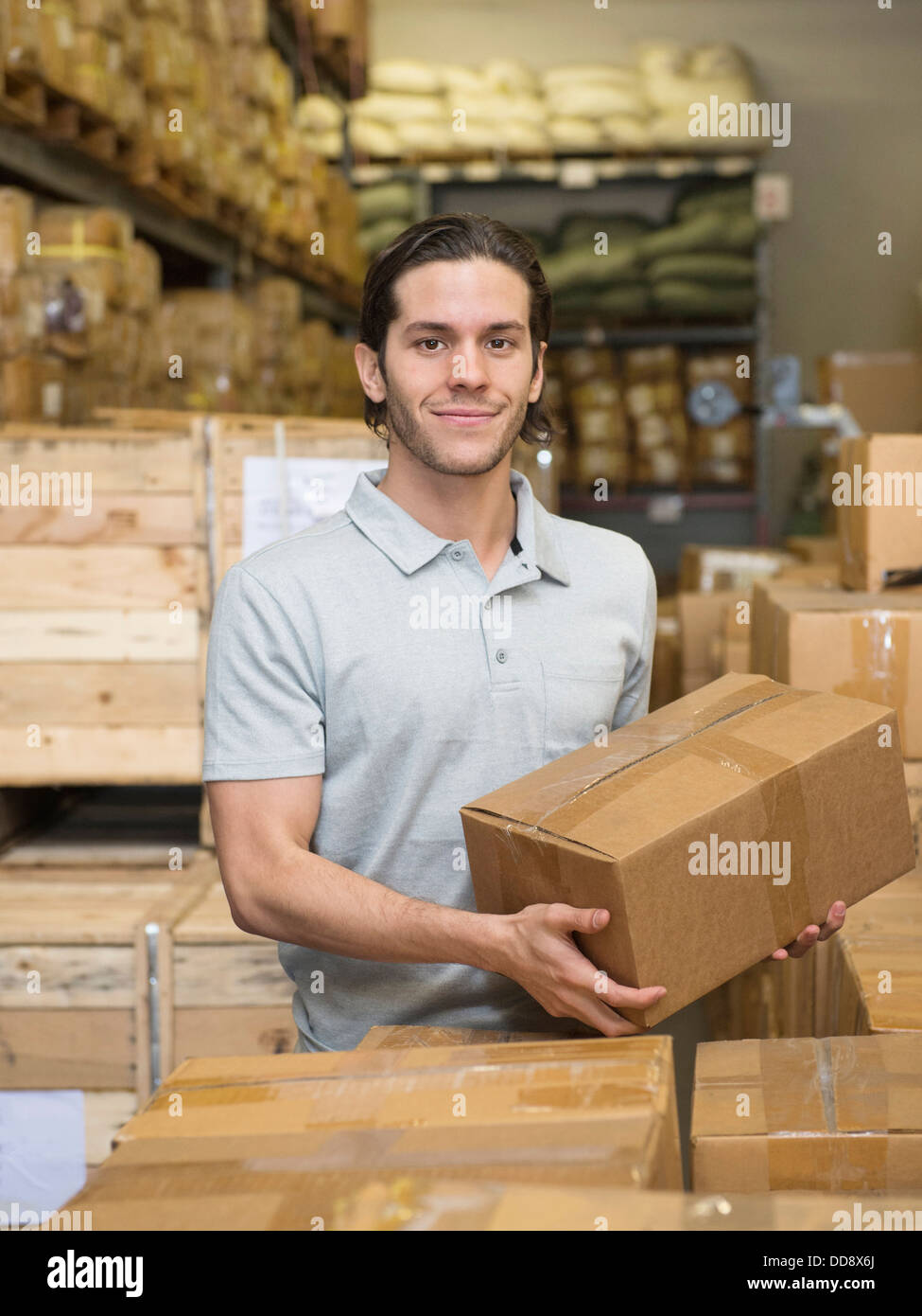 Mixed race worker stacking boxes in textile factory Stock Photo - Alamy