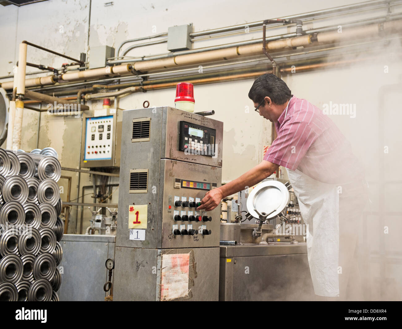 Hispanic worker operating machinery in textile factory Stock Photo - Alamy