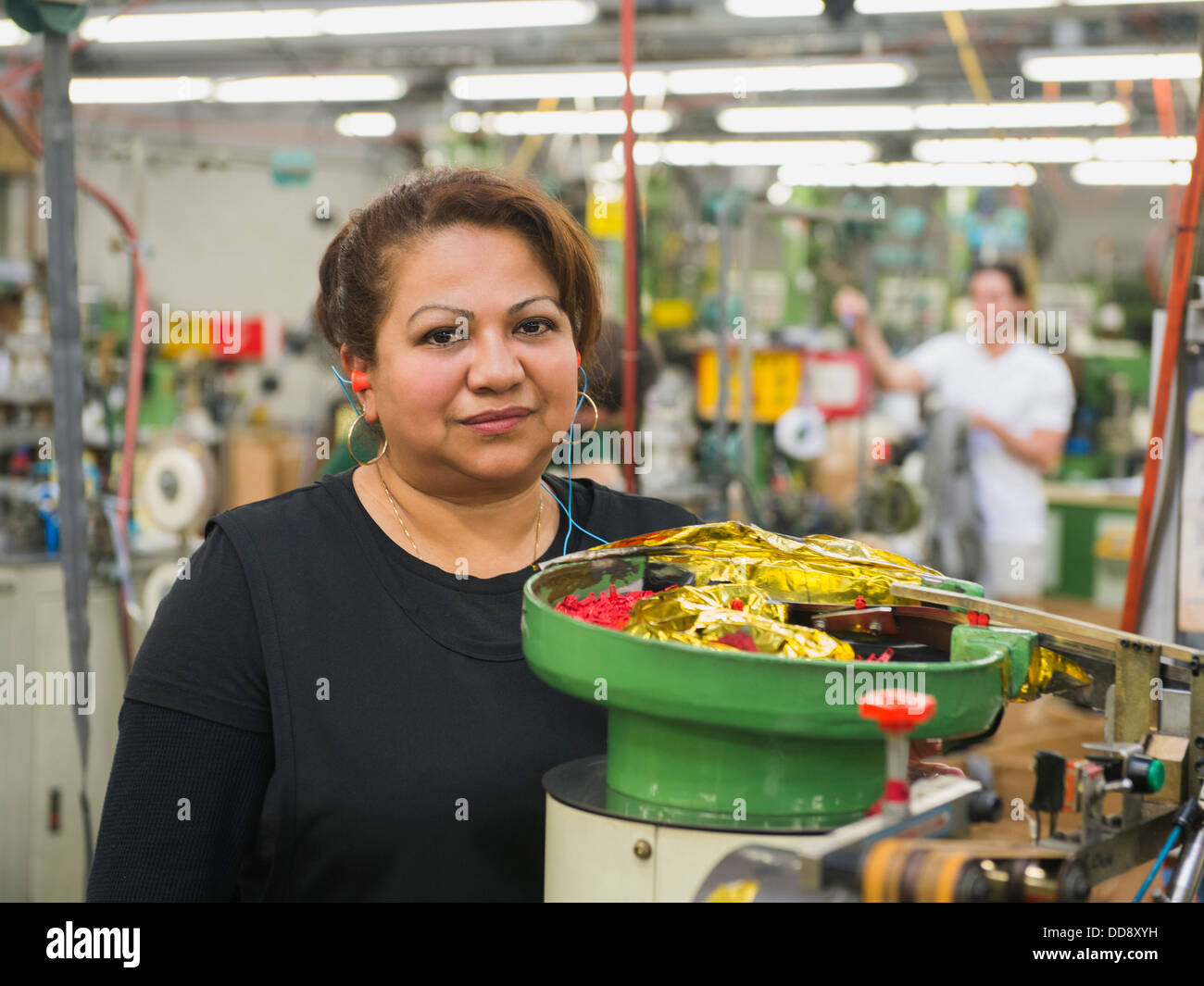Hispanic worker operating machinery in textile factory Stock Photo - Alamy