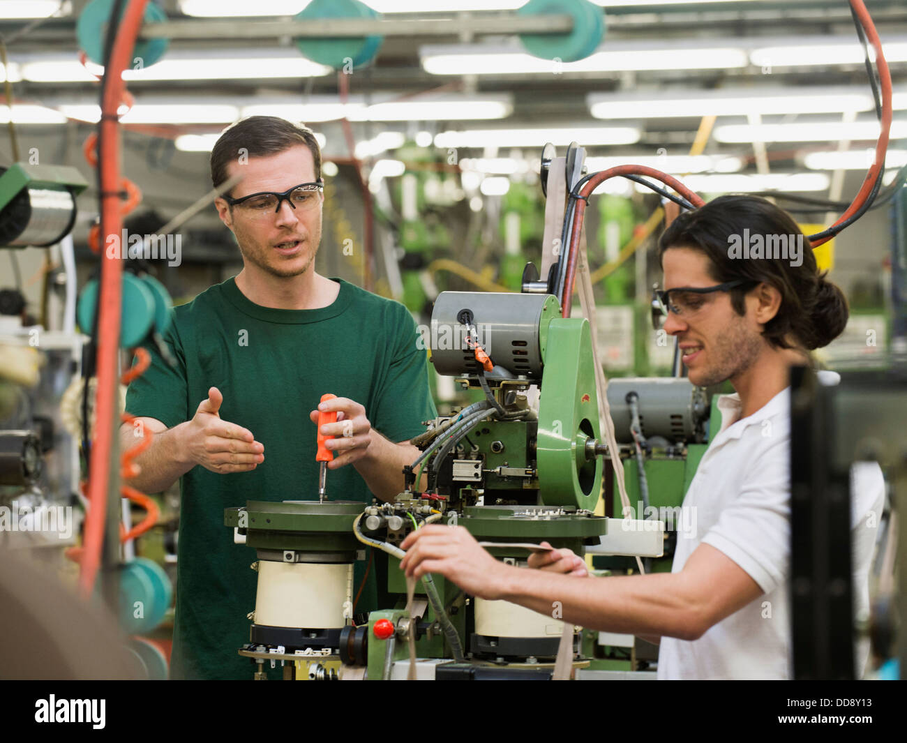 Workers operating machinery in textile factory Stock Photo - Alamy