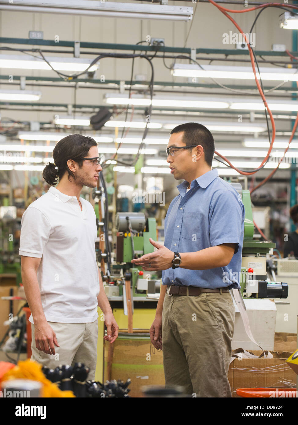 Workers talking in textile factory Stock Photo - Alamy