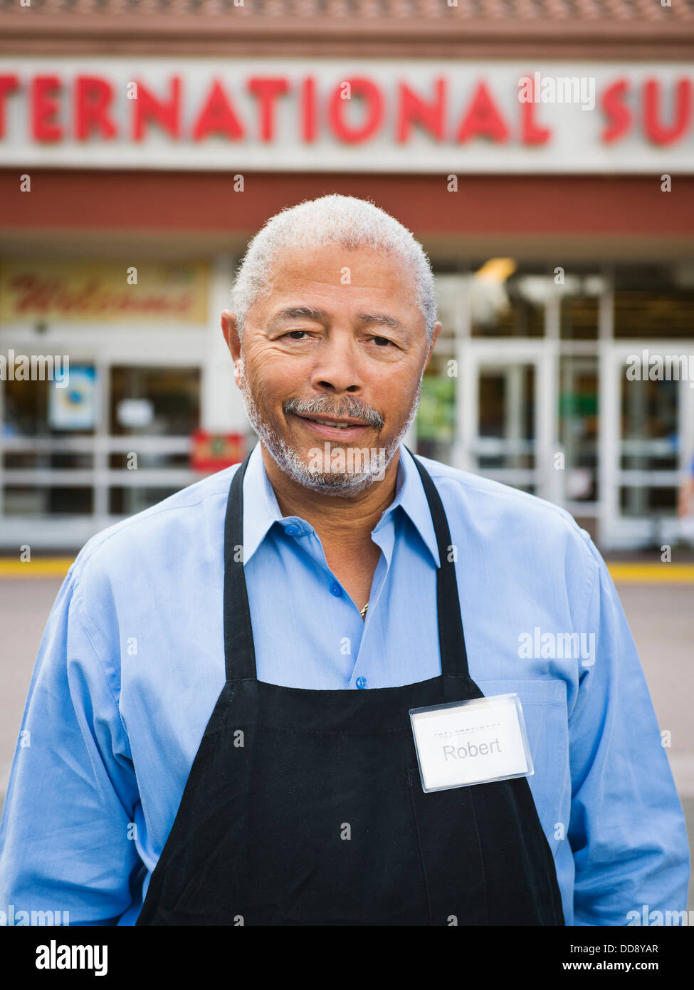 African American worker smiling outside grocery store Stock Photo - Alamy