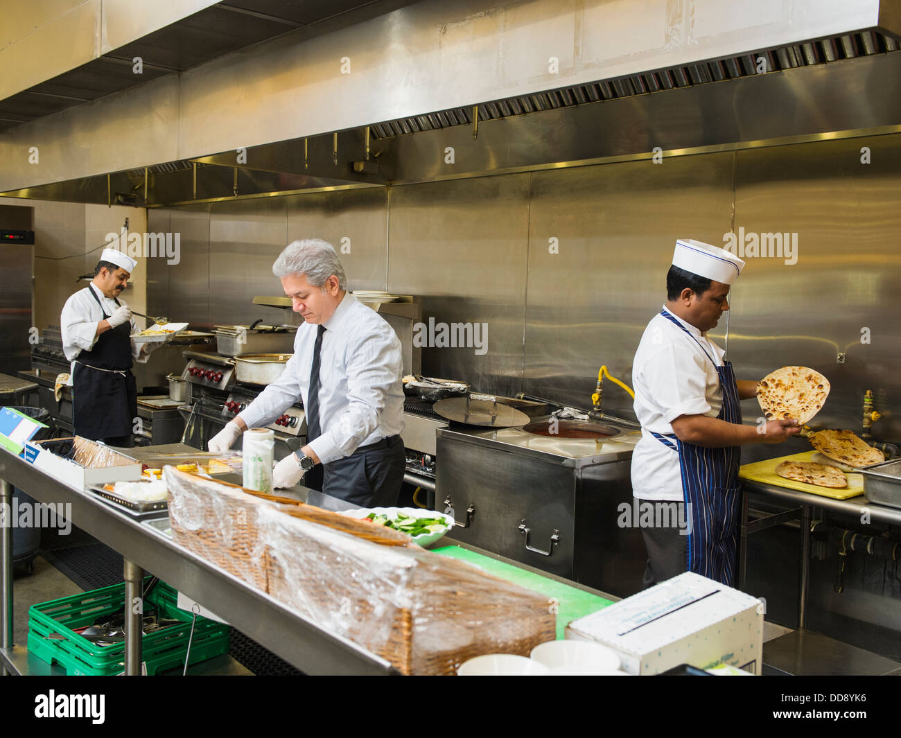 Businessman and chefs working in kitchen Stock Photo - Alamy