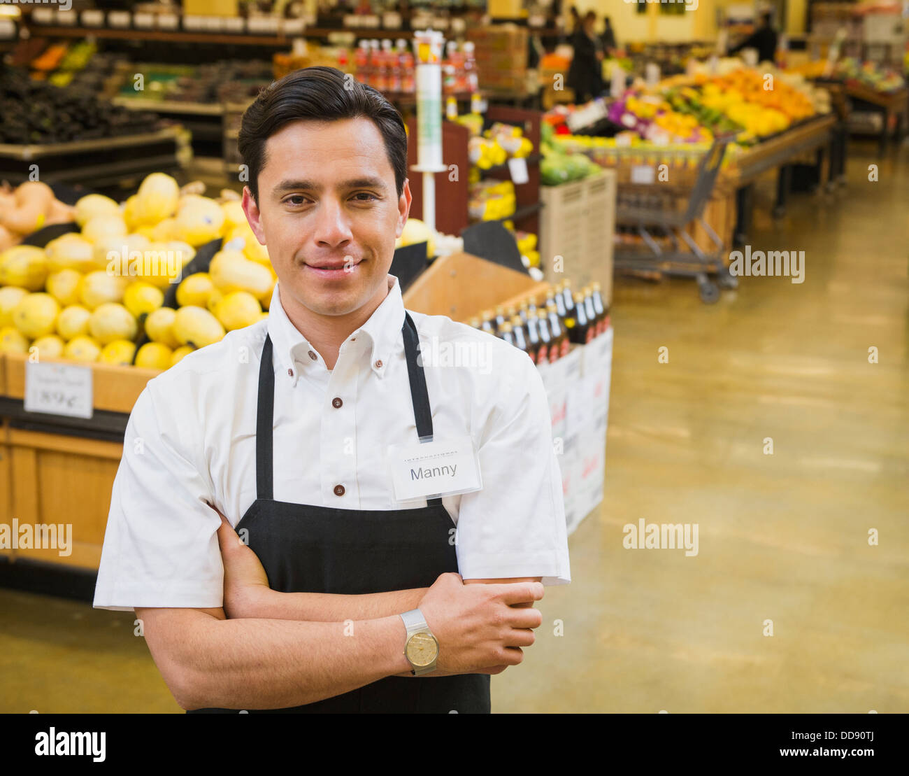 Hispanic worker smiling in grocery store Stock Photo - Alamy