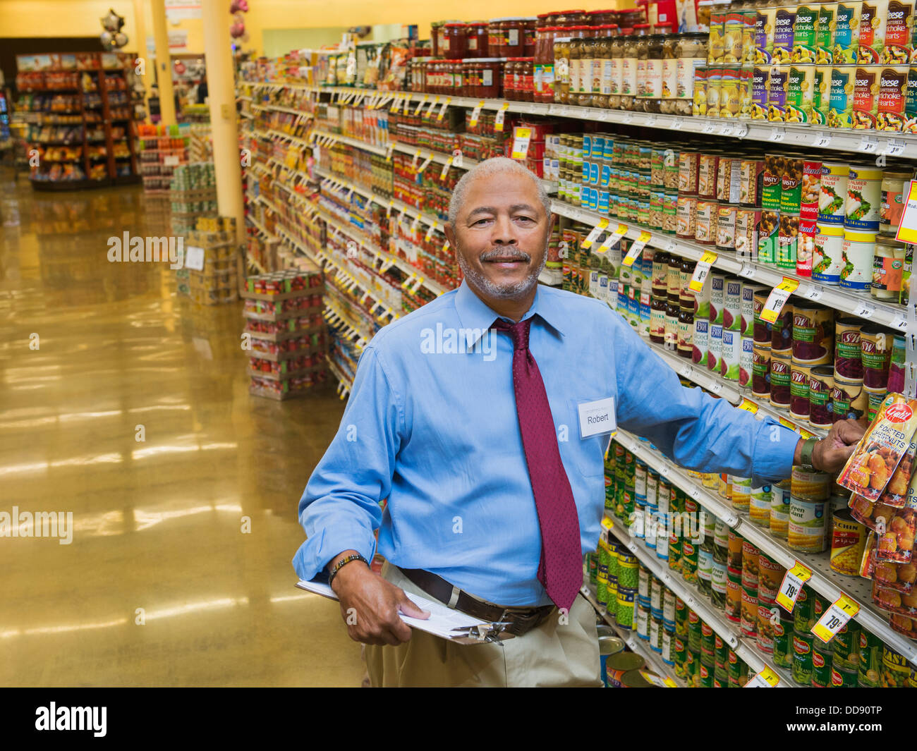 African American businessman smiling in grocery store Stock Photo - Alamy