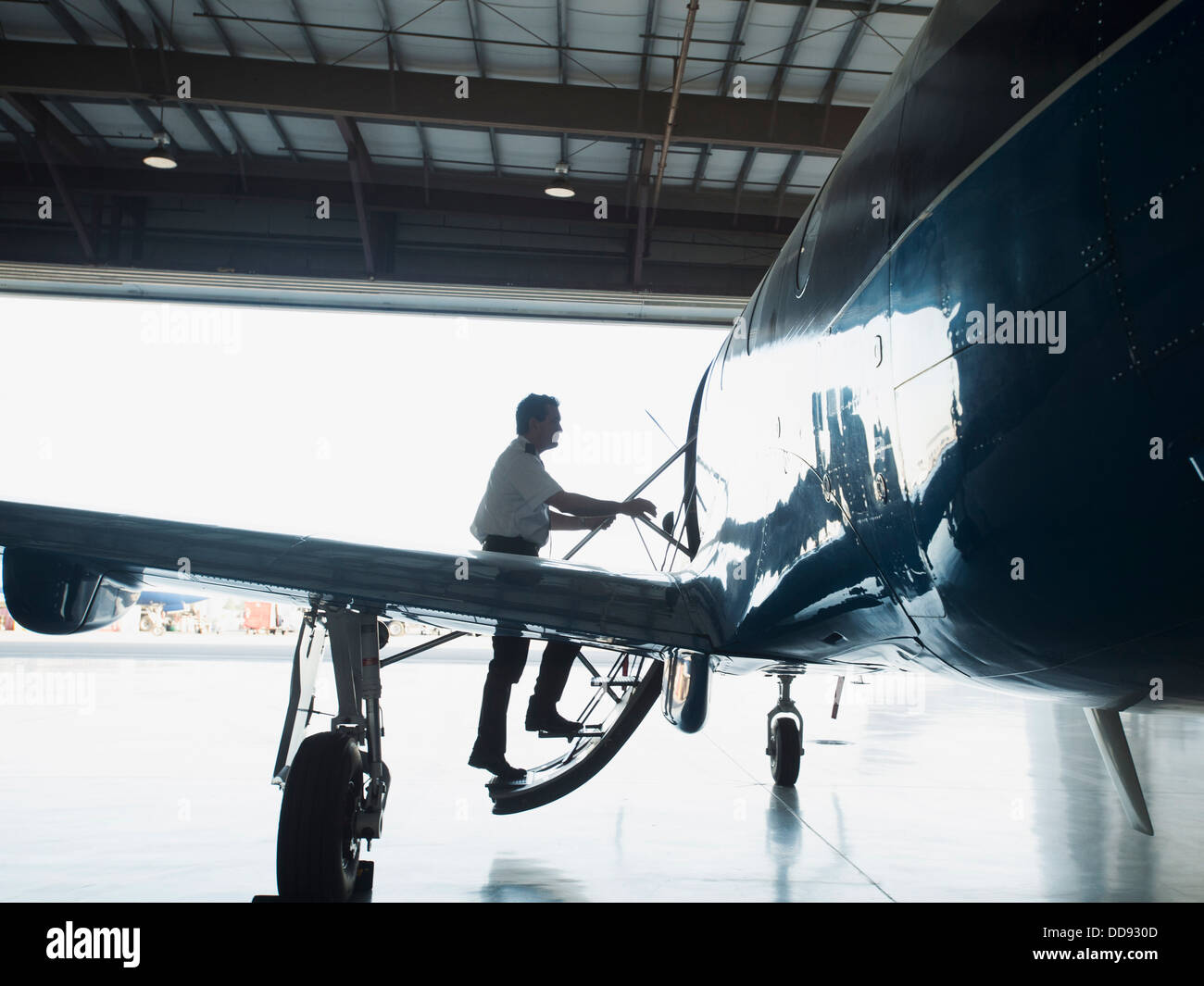 Caucasian pilot boarding airplane in hangar Stock Photo - Alamy