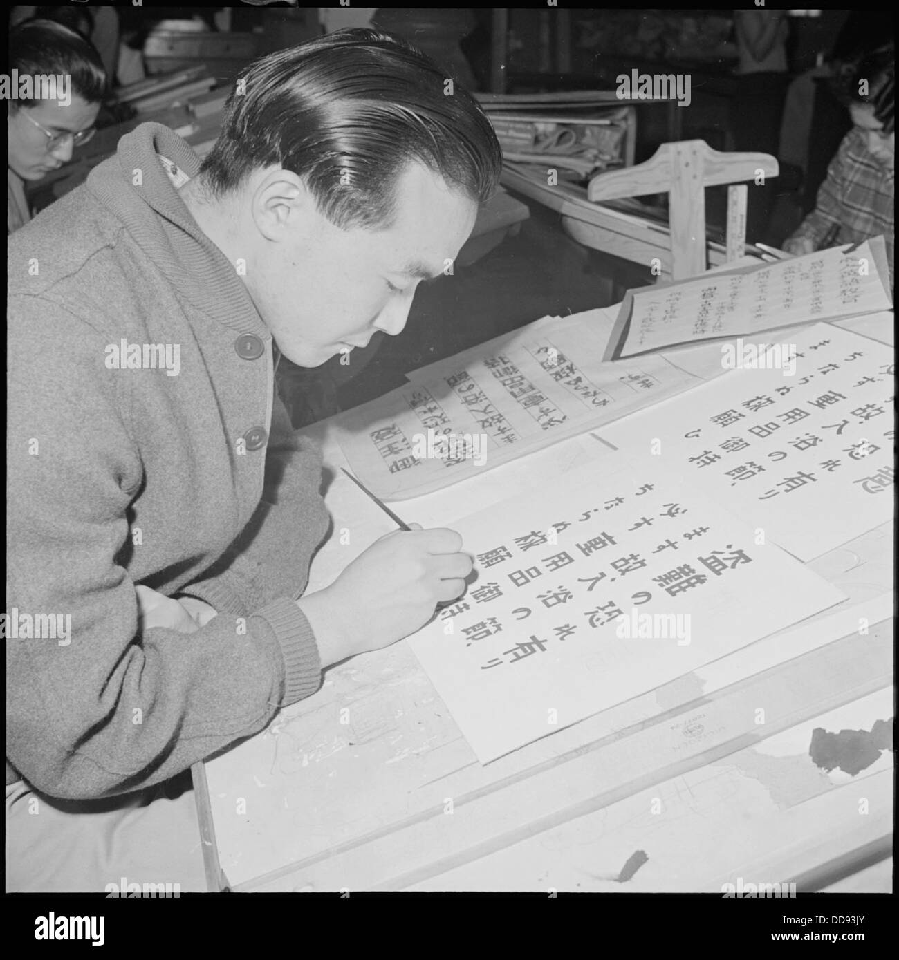 This image depicts a young artist working in the Poster Shop at the ...