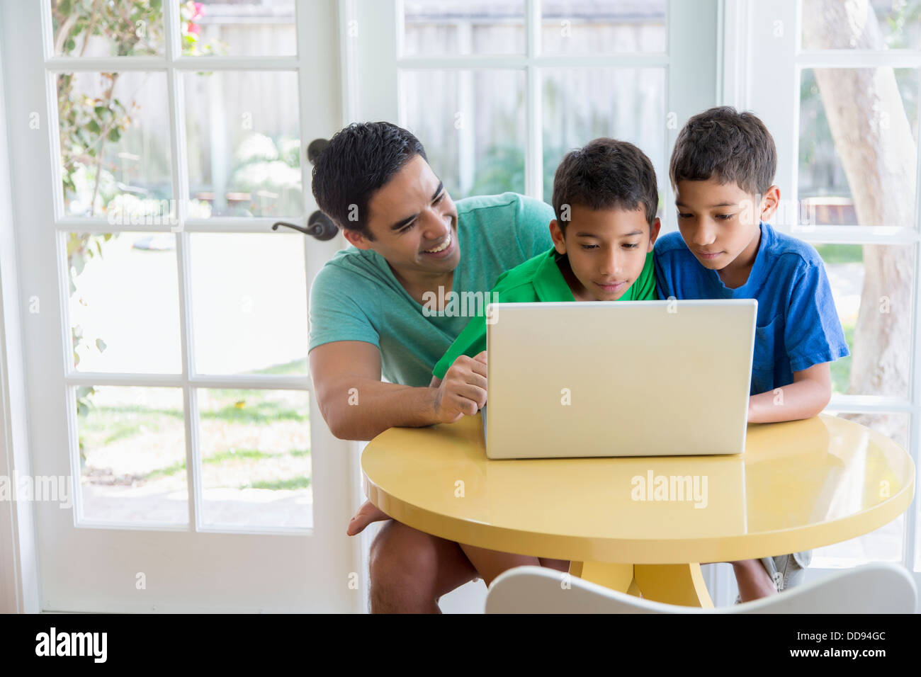 Hispanic father and sons using laptop Stock Photo - Alamy