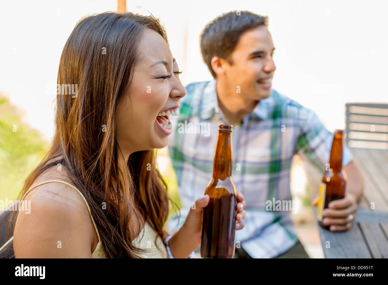 Couple having beers in backyard Stock Photo - Alamy