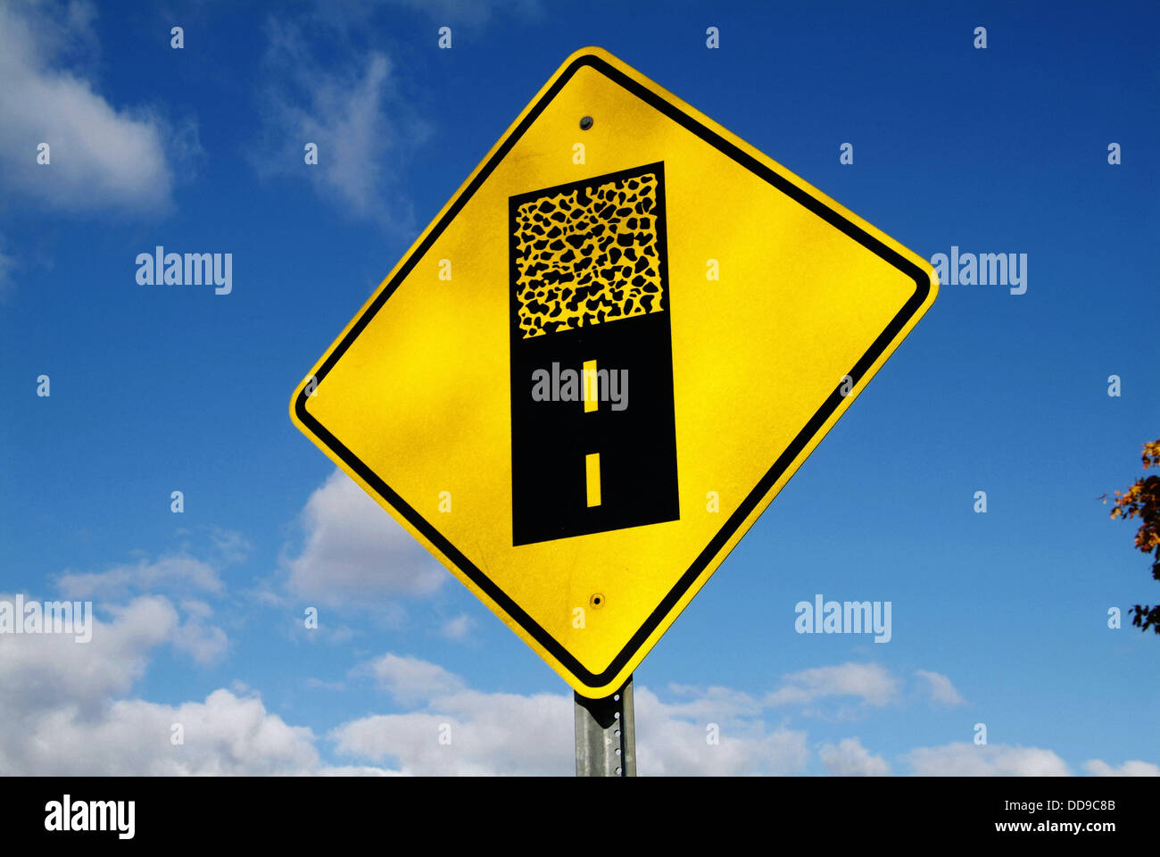 Traffic sign alerting motorist drivers that paved highway turns into a ...