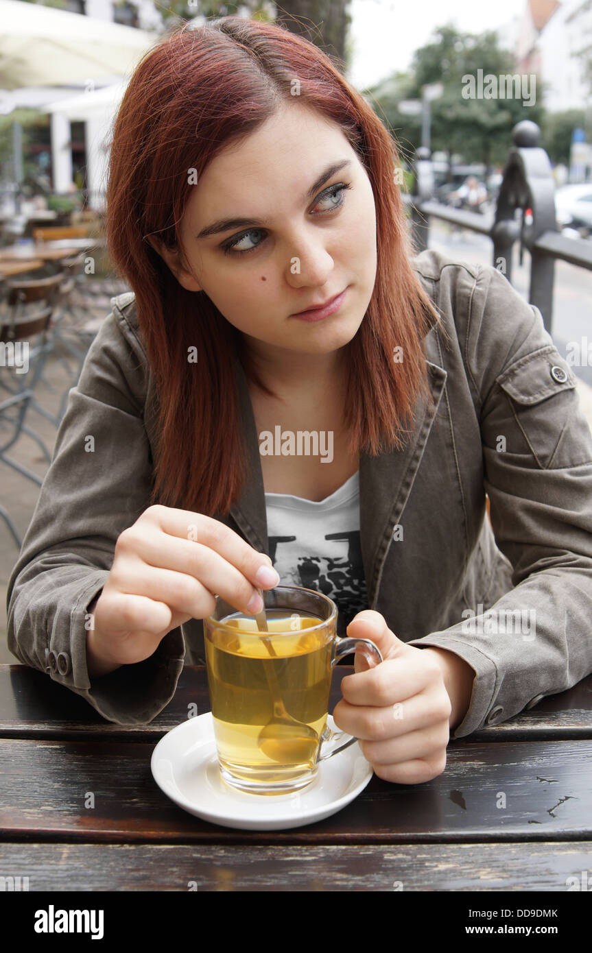 young woman drinking tea in an outdoor cafe Stock Photo - Alamy
