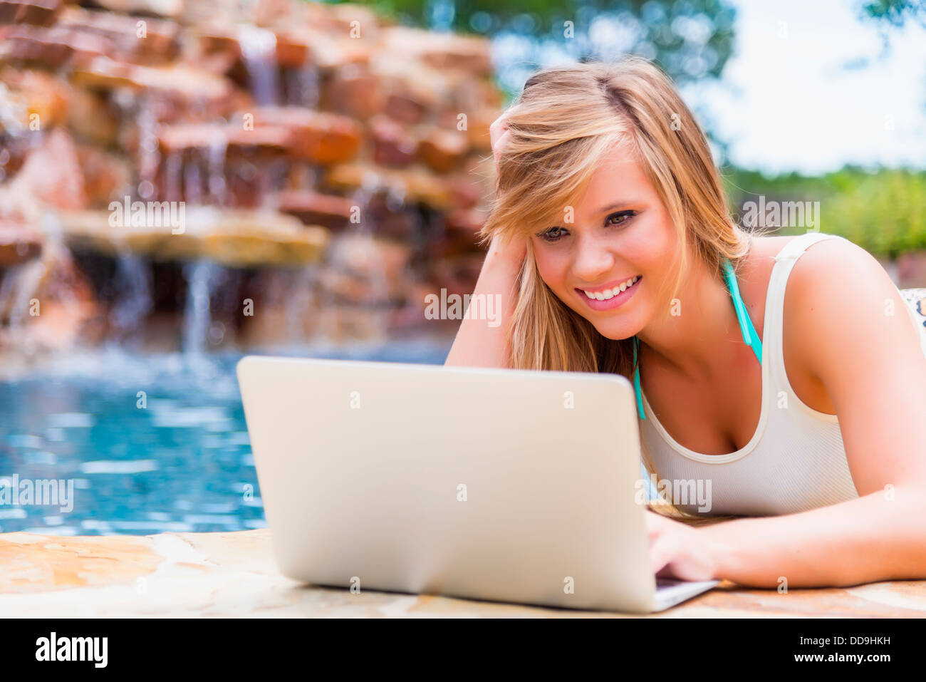 Woman using laptop swimming pool hi-res stock photography and images ...