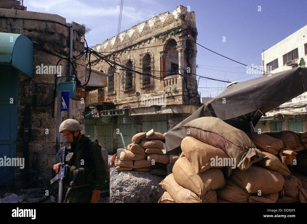 An armed Israeli soldier stands guard at in the deserted Palestinian ...