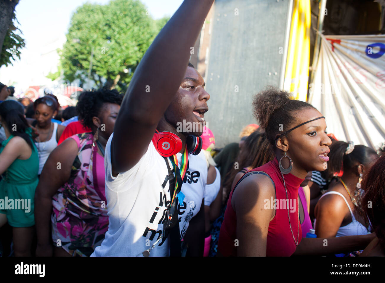 Young men and women dance to the carnival music along a float passing ...