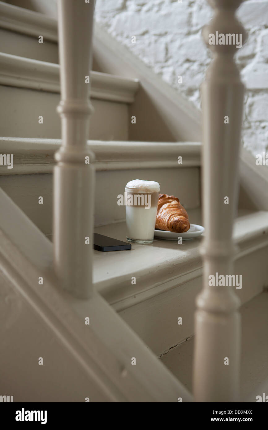 Croissant and drink on steps with mobile phone Stock Photo - Alamy