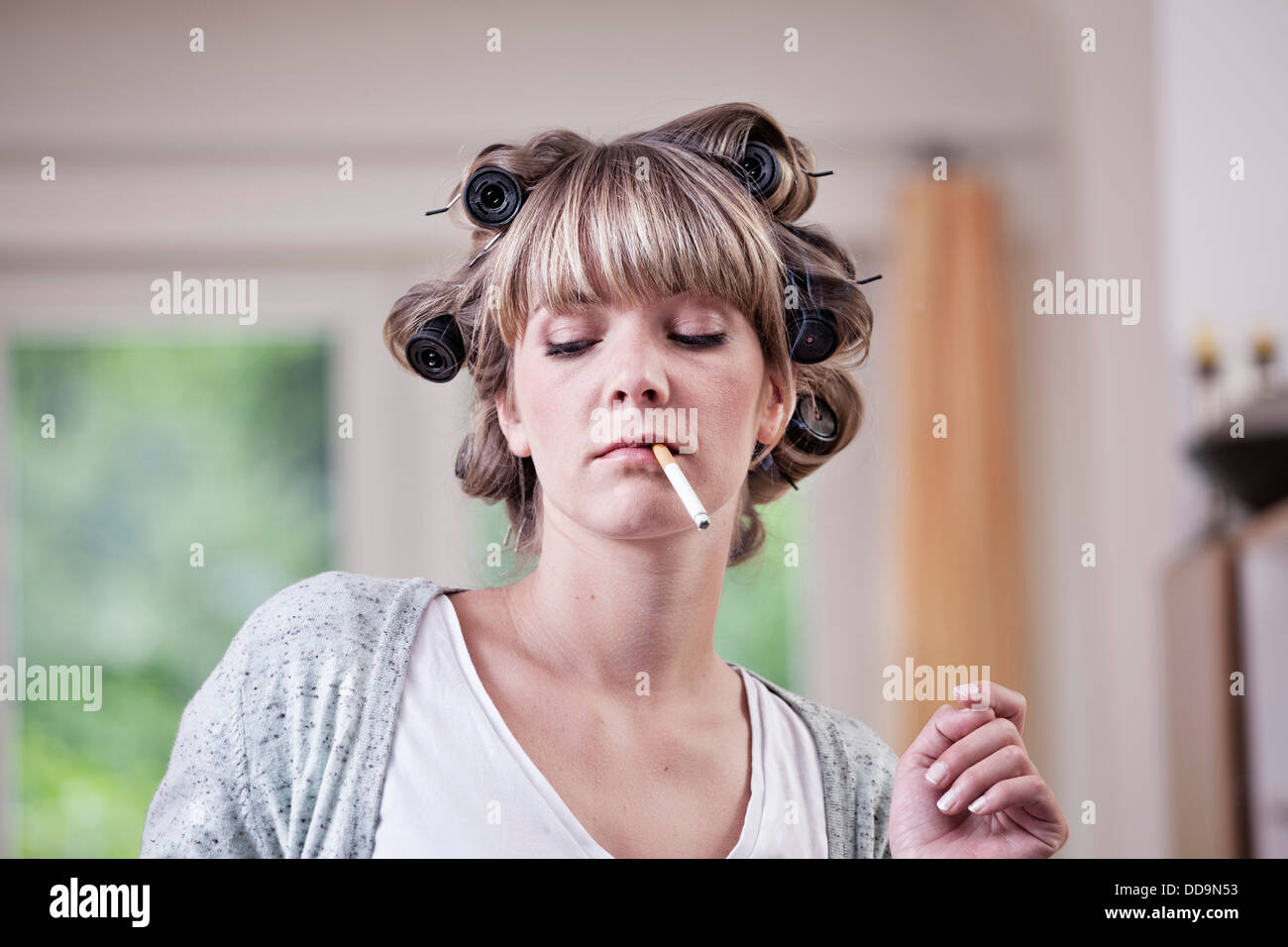 Germany, North Rhine Westphalia, Cologne, Young woman smoking cigarette ...