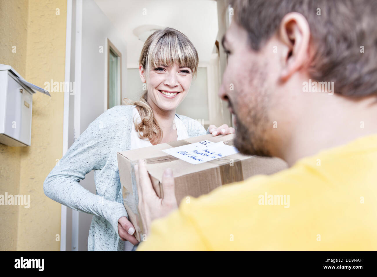 Germany, North Rhine Westphalia, Cologne, Young woman taking pizza box ...