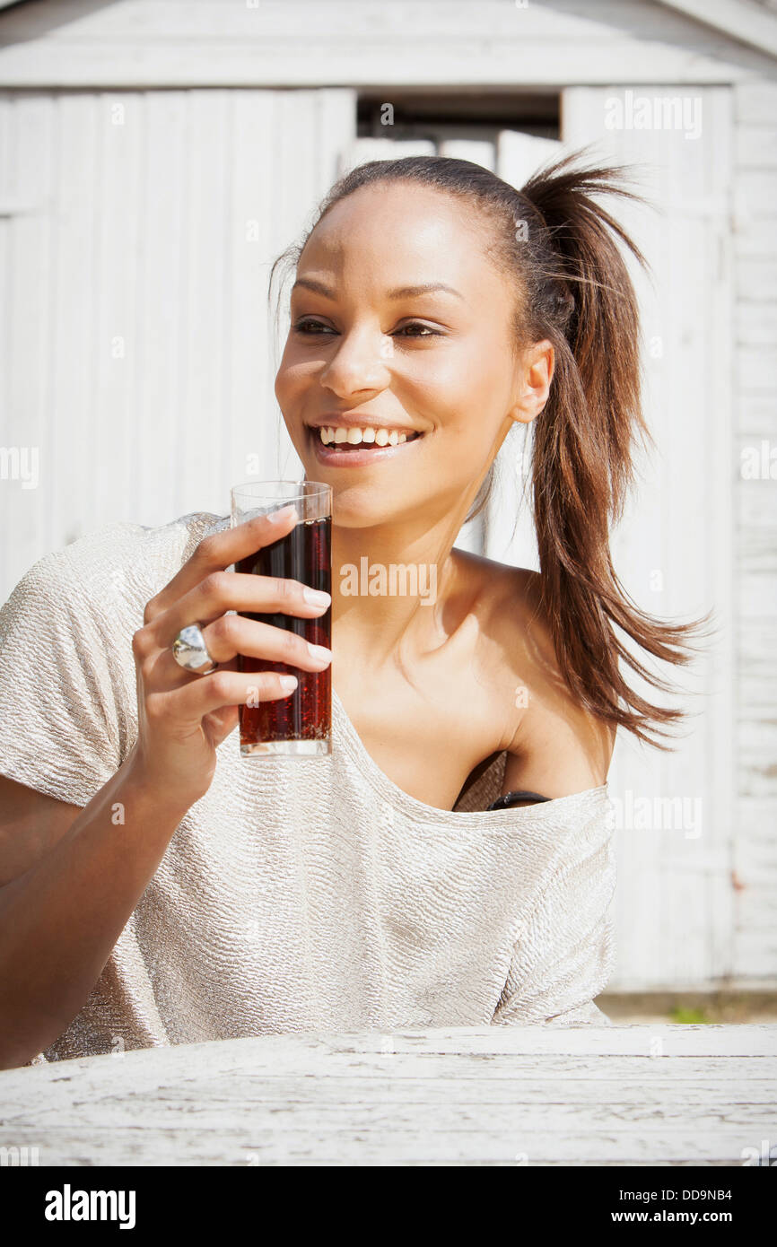 Germany, Young woman holding glass of coke, smiling Stock Photo - Alamy