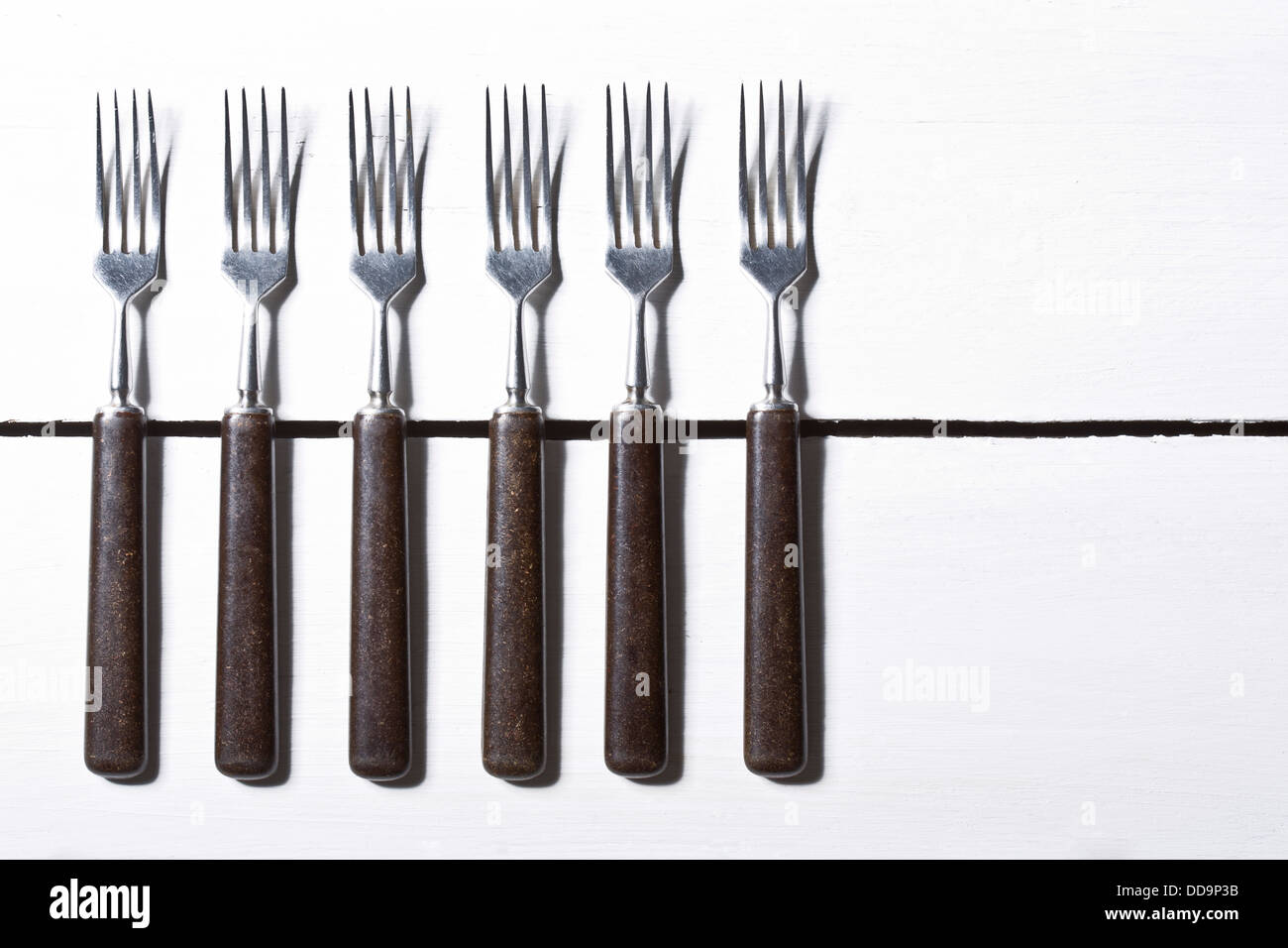 Forks on wooden table, close up Stock Photo - Alamy