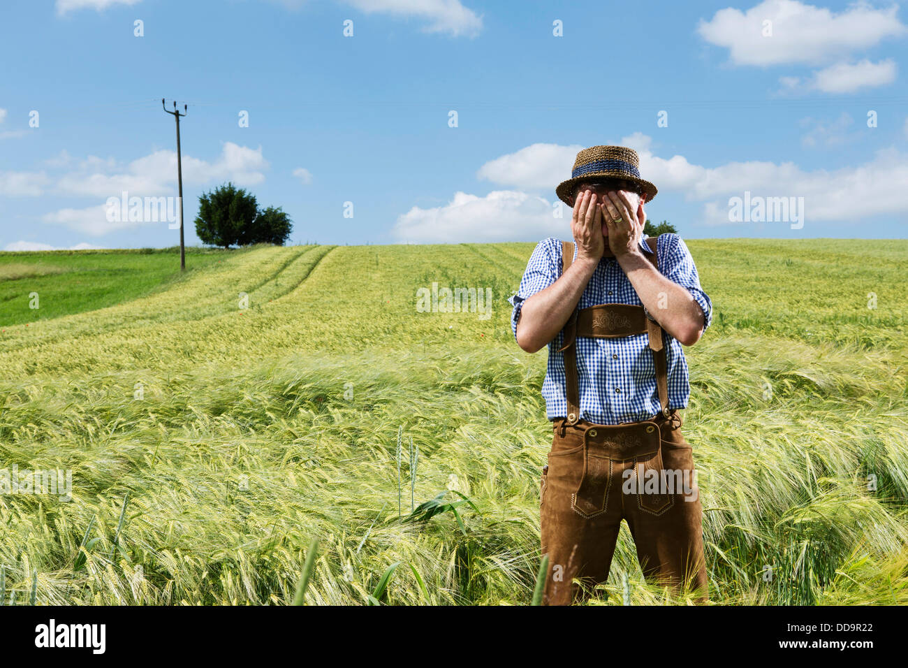 Germany, Bavaria, Farmer covering his face in field Stock Photo - Alamy