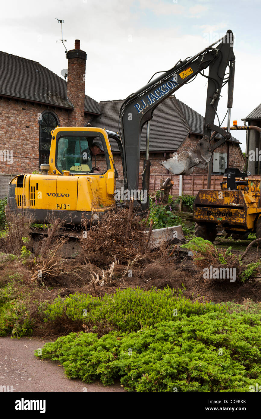 self building house, excavator digging up garden to prepare site for ...