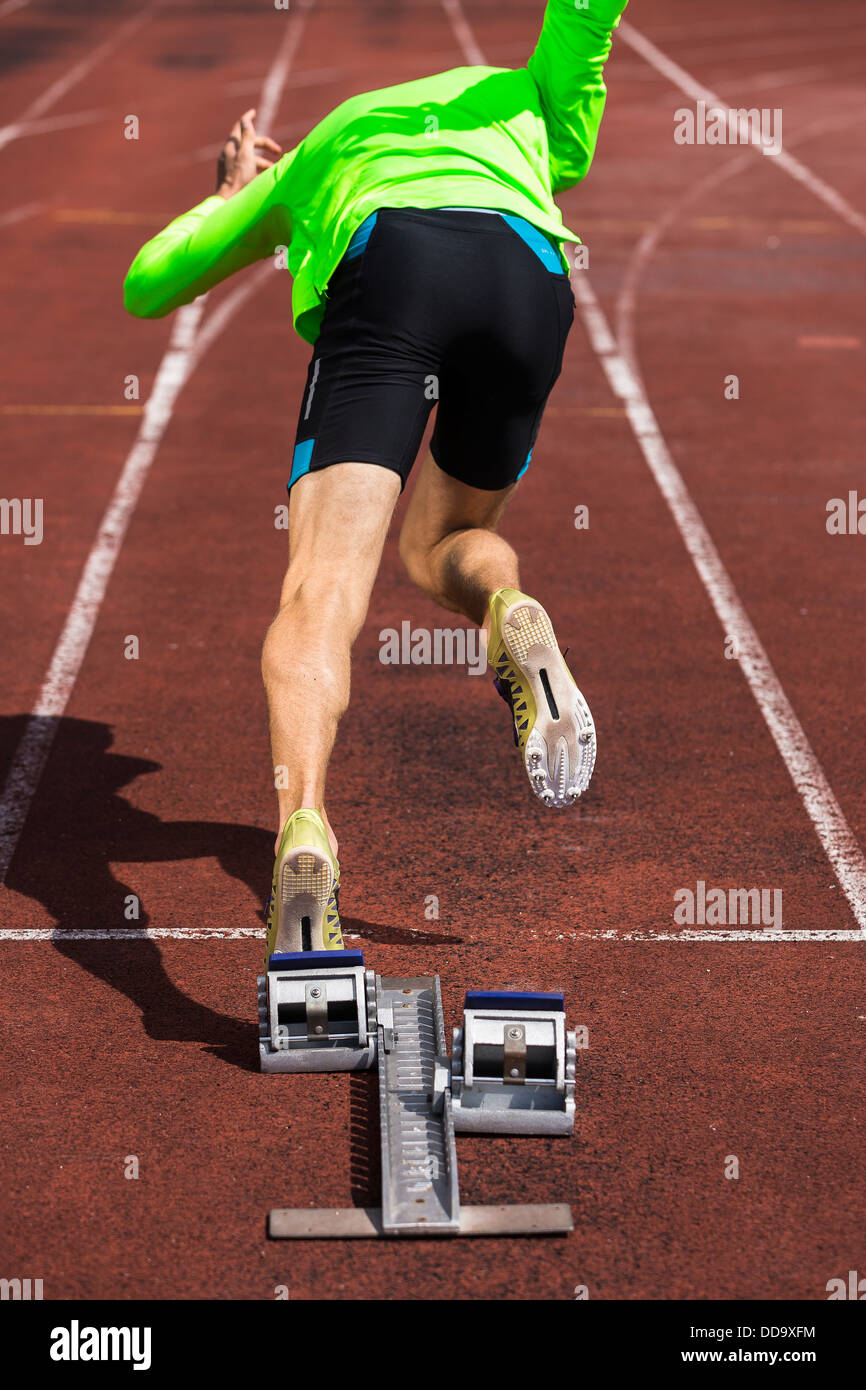 Germany, Young man running from sprint start Stock Photo - Alamy