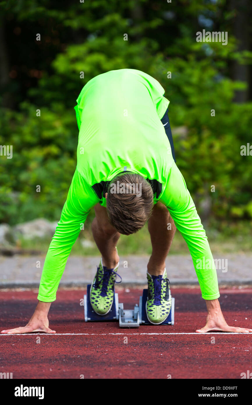 Germany, Young man running from sprint start Stock Photo - Alamy