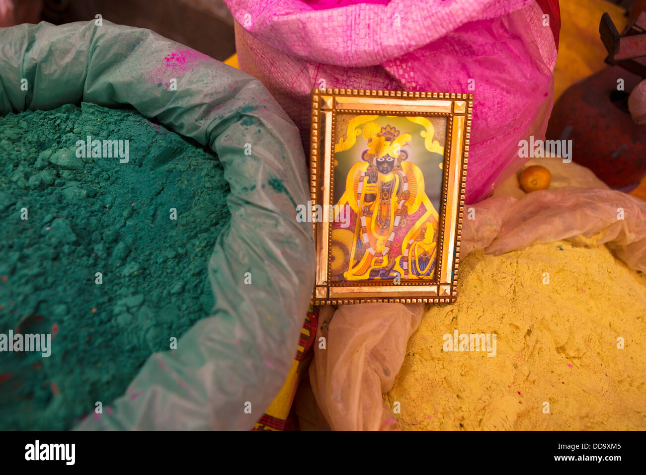 A picture of Krishna in a store which sells colored powder to celebrate ...