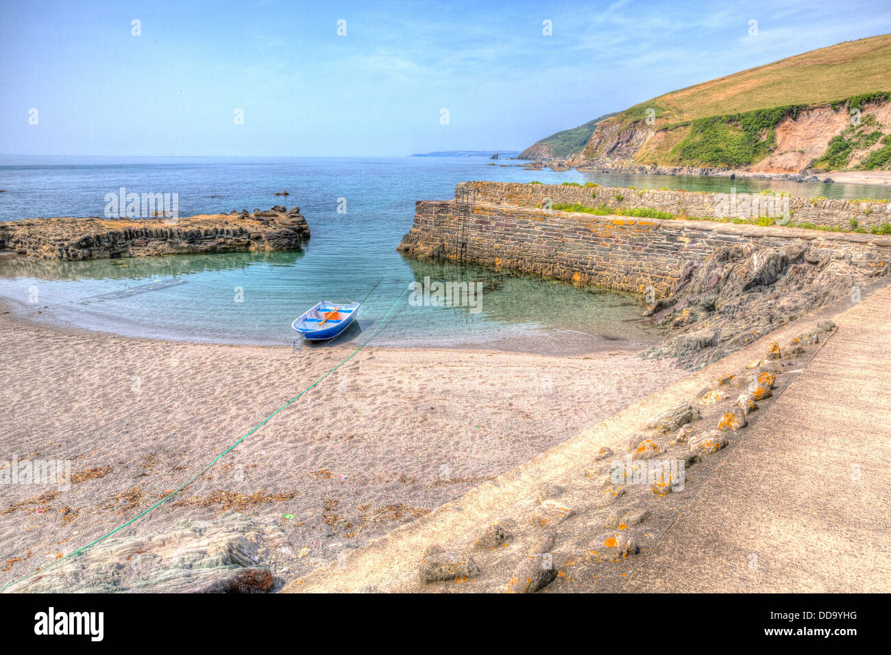 Tiny harbour Portwrinkle Cornwall with single rowing boat and blue sea ...