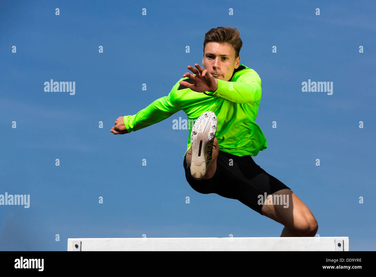 Germany, Man athlete jumping Hurdles on track Stock Photo - Alamy