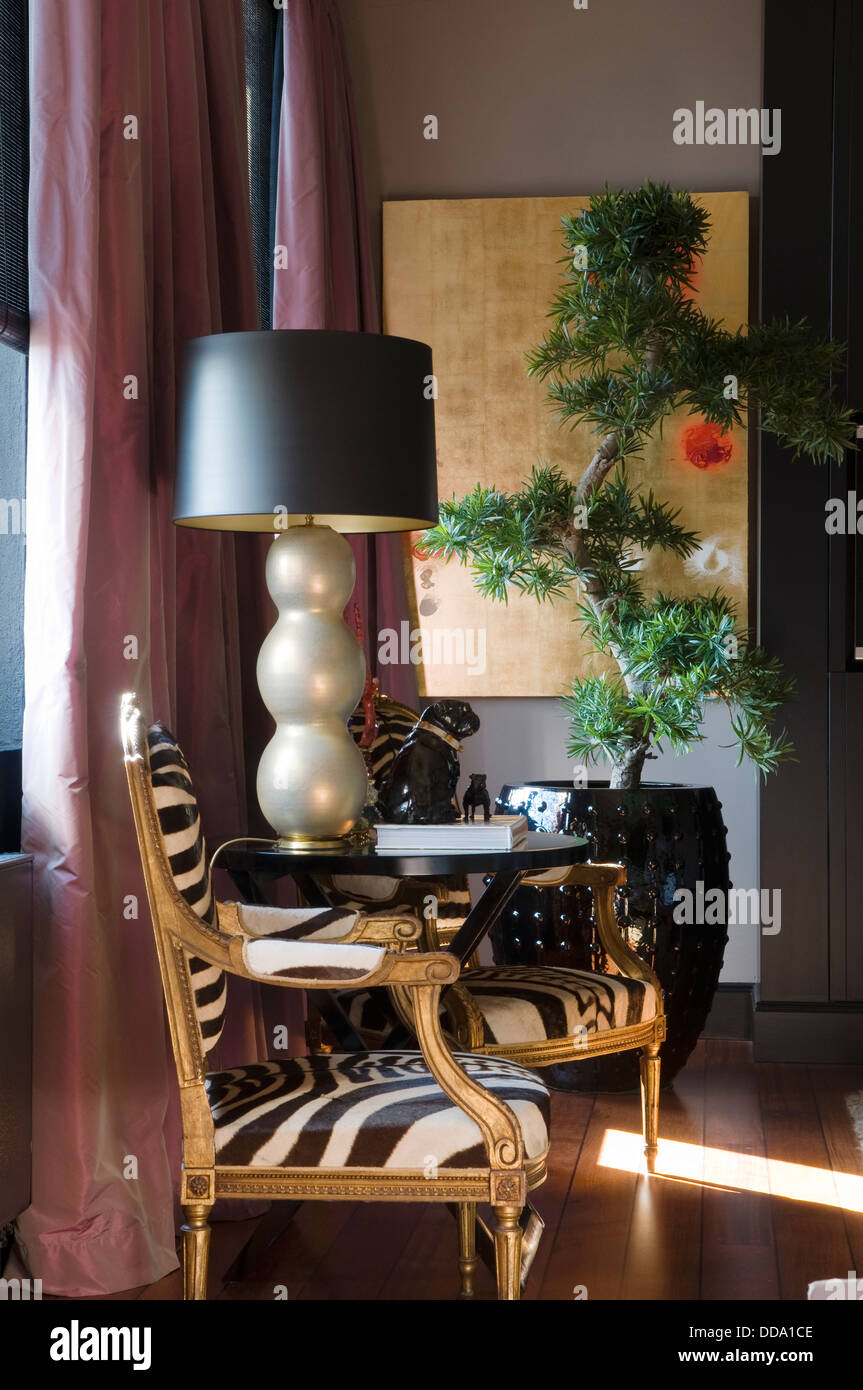 Artwork by Robert Weber with dramatic lamp and faux bonsai Stock Photo ...