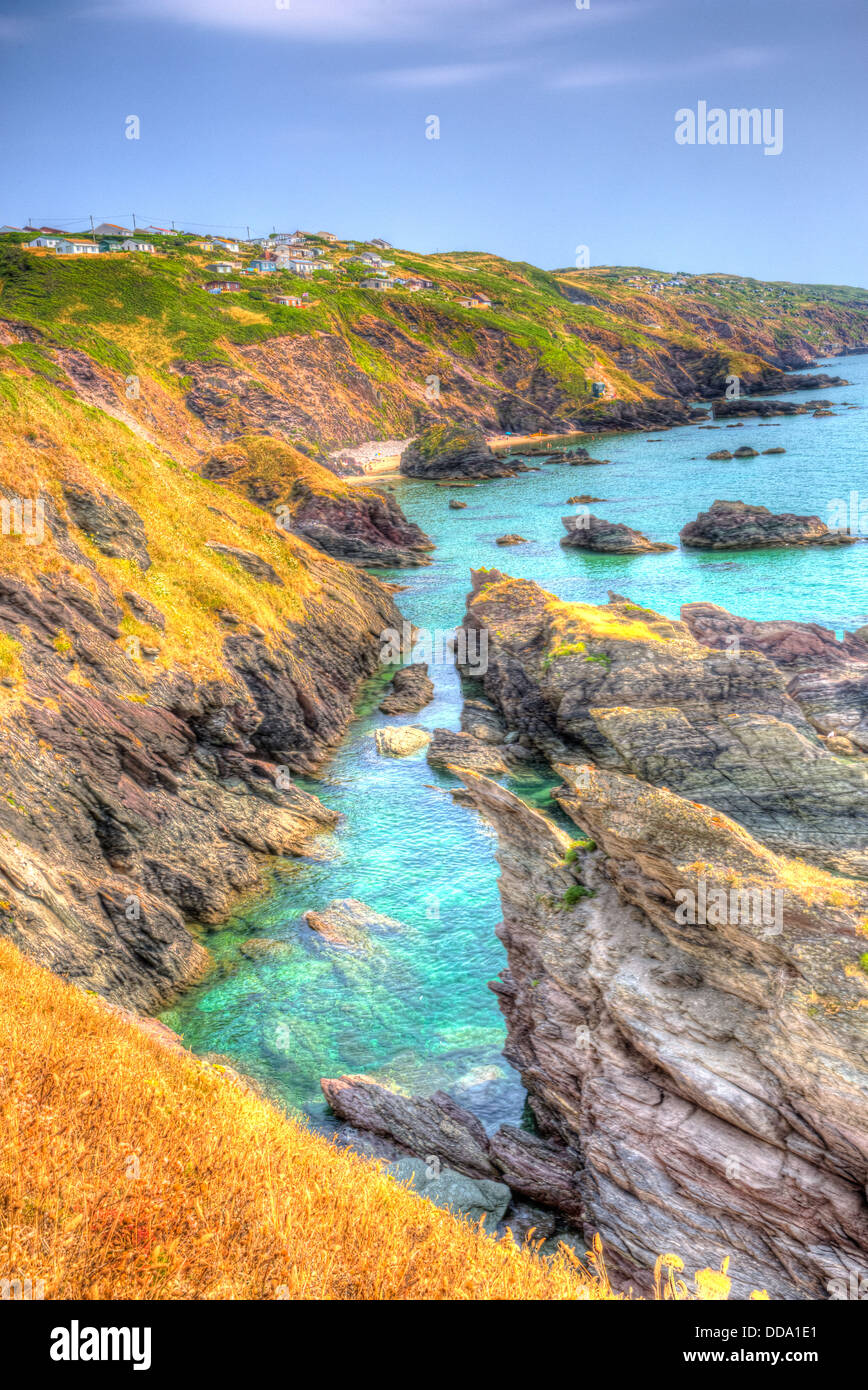 Rugged coast of Cornwall with bright and vivid colours blue sea and sky ...