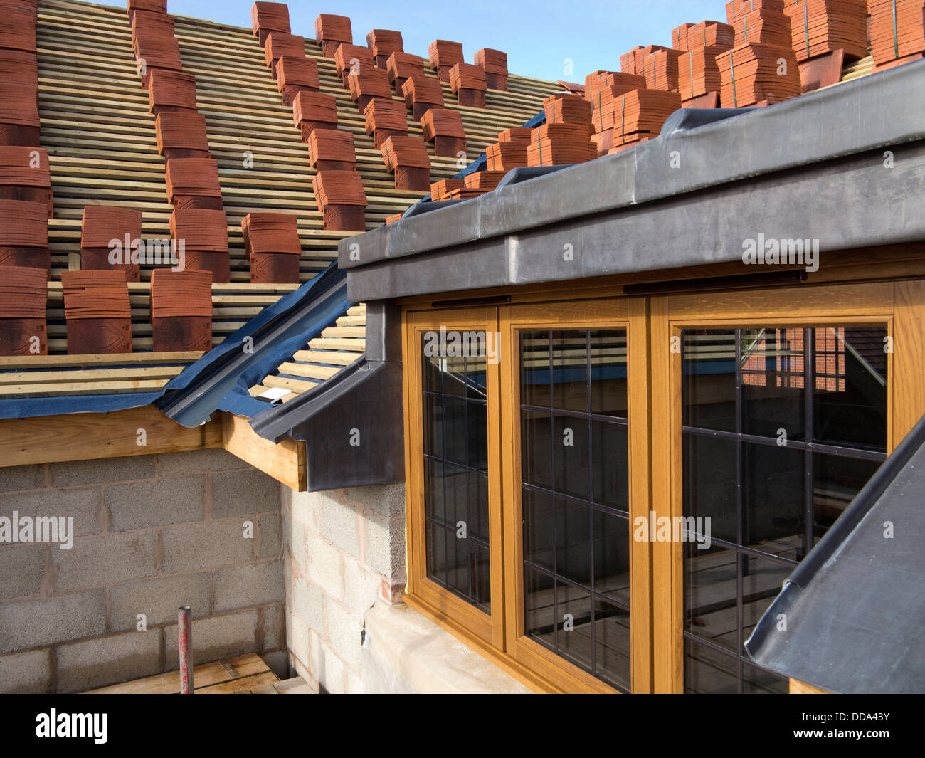 self building house, constructing roof, clay tiles stacked on wooden ...