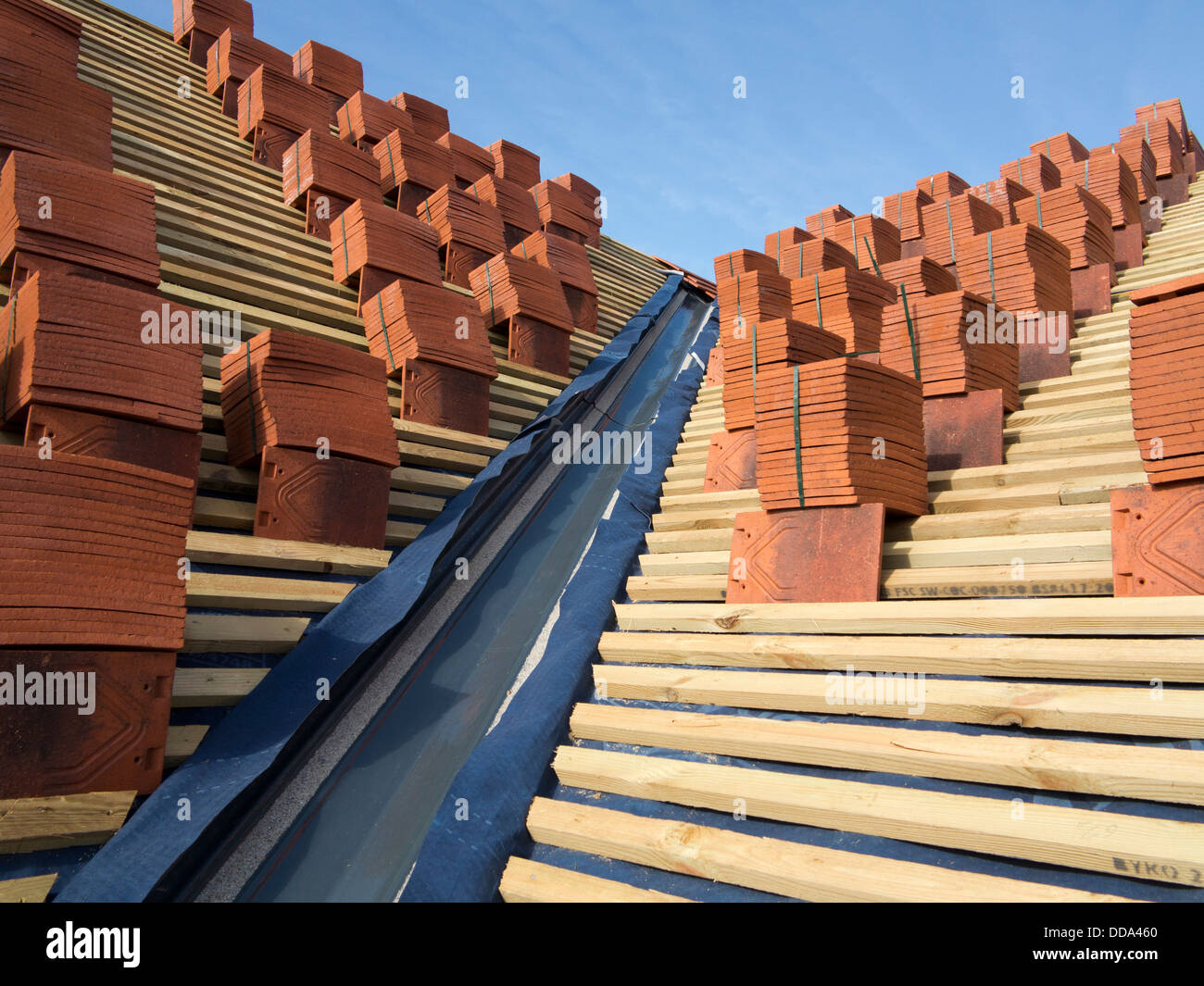 self building house, constructing roof, clay tiles stacked on wooden ...