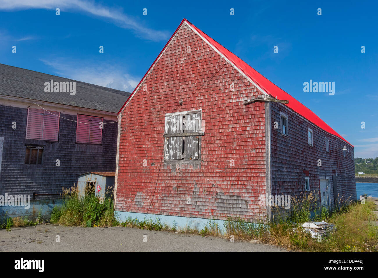 A red wooden shingled fishing building with a red metal roof by the ...
