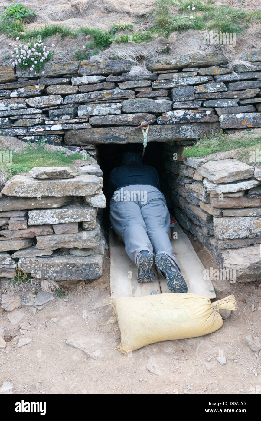 A visitor prepares to enter the Tomb of the Eagles chambered tomb on ...