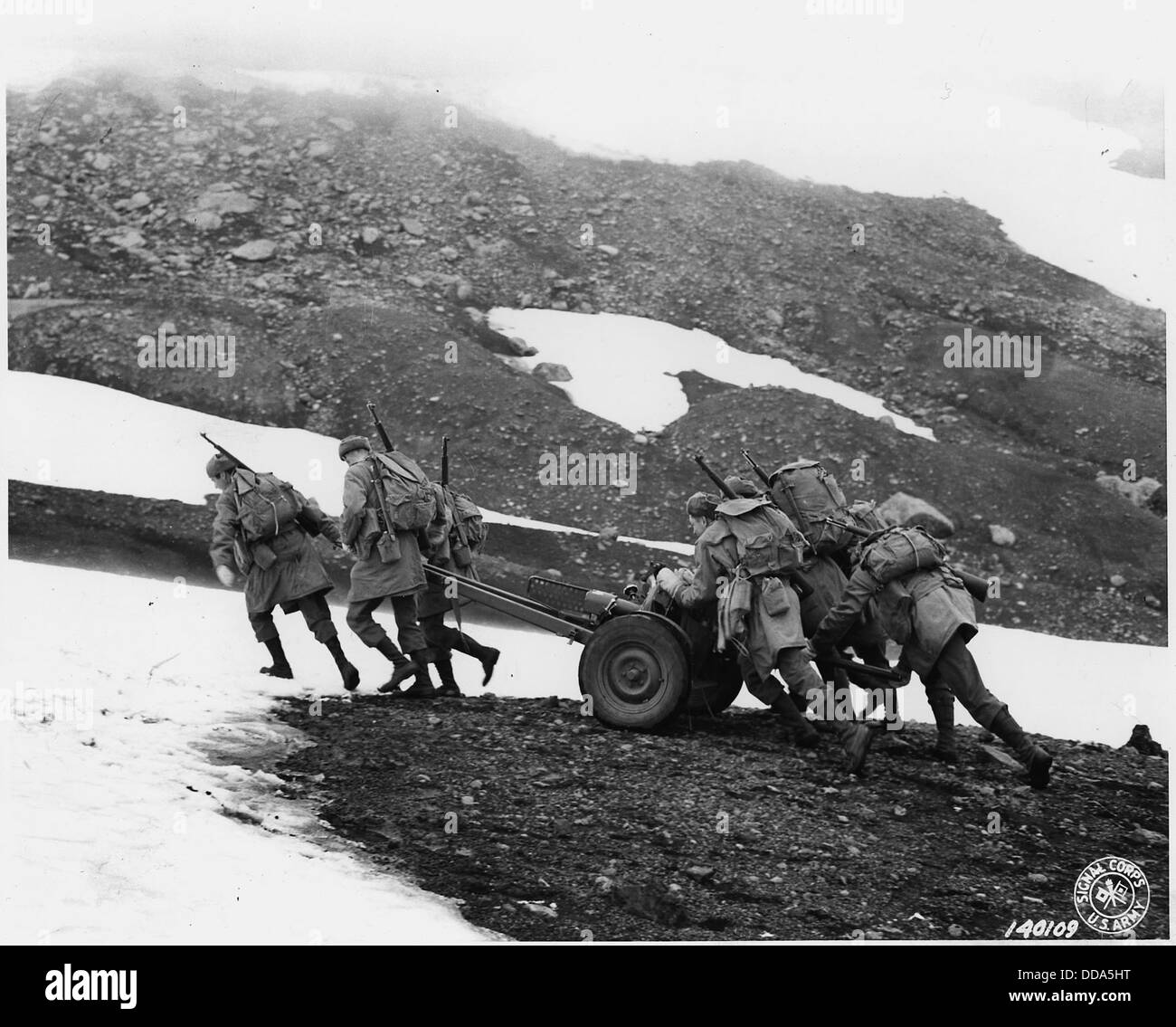 Infantry soldiers transport a 37mm gun up a mountain pass in Alaska ...