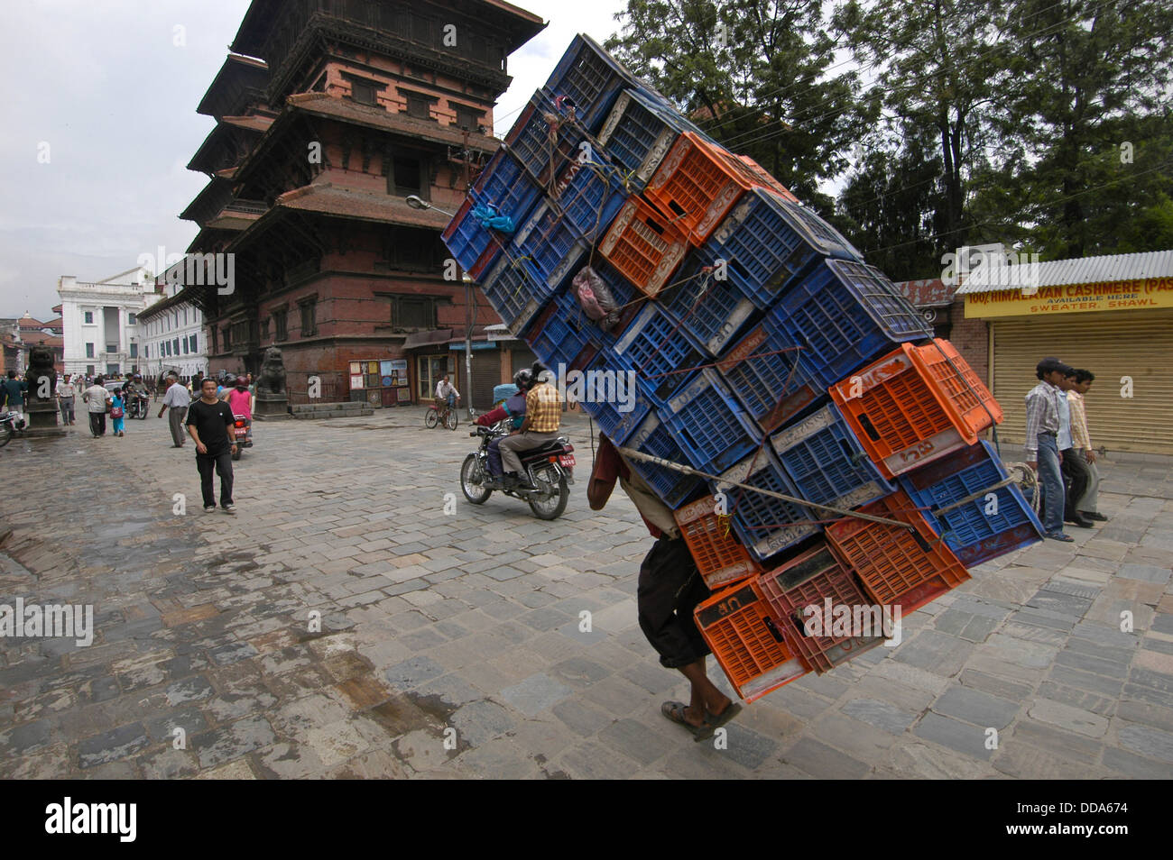 A man carrying a heavy weight with his back Stock Photo - Alamy