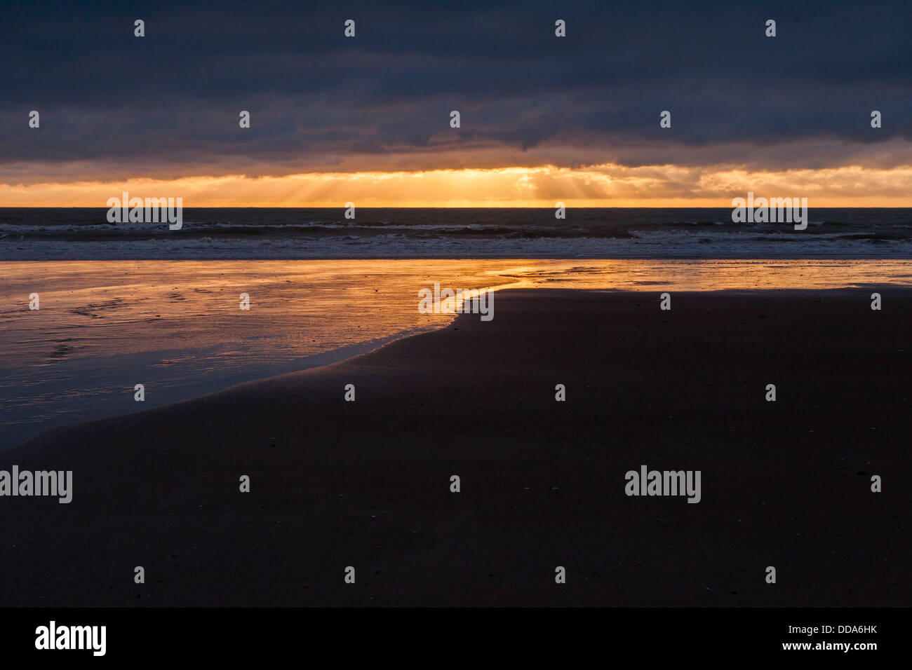 Sunset Over Water with Heavy Cloud and Rays - sunrise over Moeraki ...