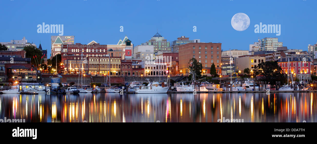 Victoria city skyline and full moon with reflections at twilight ...