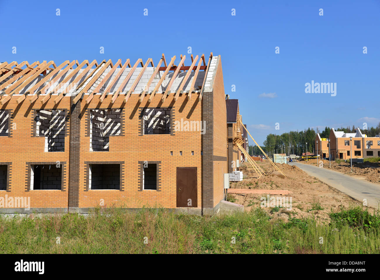 Unfinished houses of brick under construction site with wooden roof ...