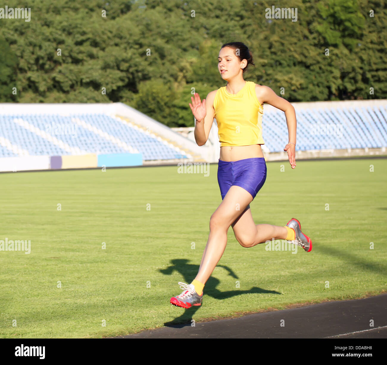 Girl running on the stadium track Stock Photo - Alamy