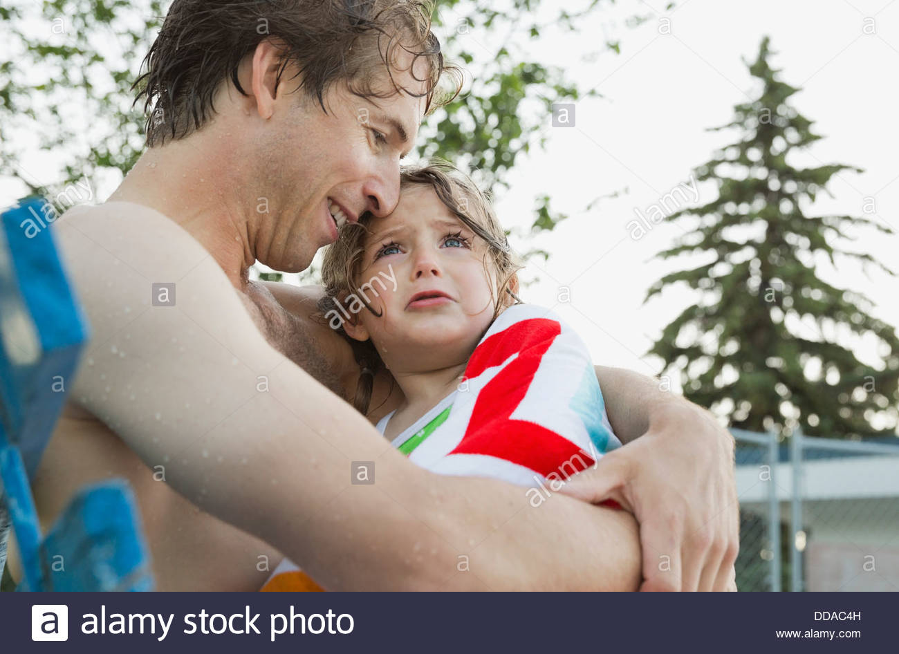 Man consoling crying daughter at swimming pool Stock Photo - Alamy