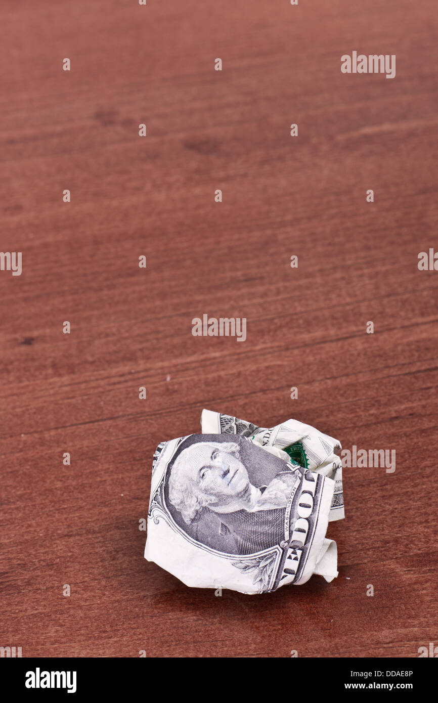 crumbled up dollar bill left shaped into a ball on a table Stock Photo ...
