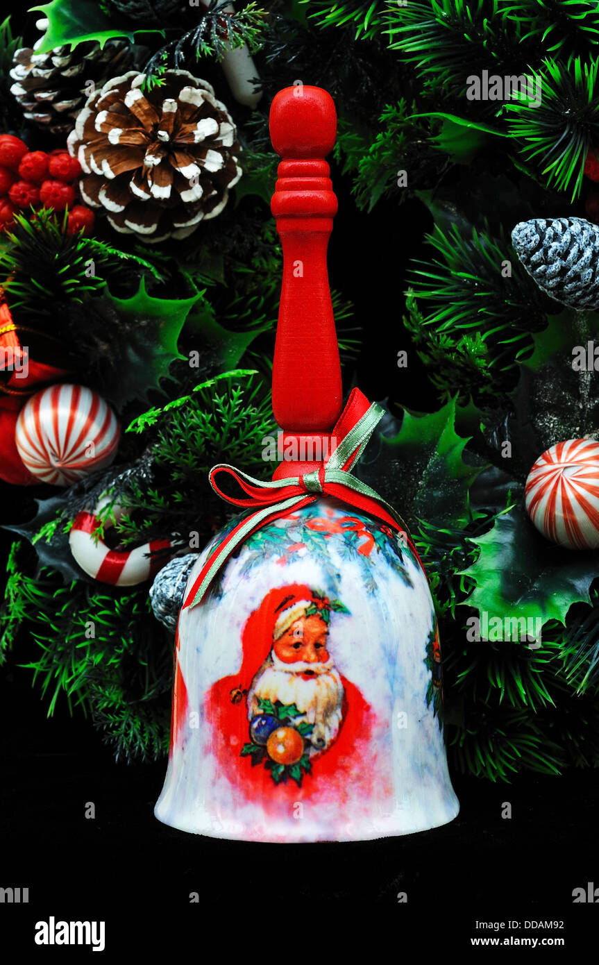 Ceramic Christmas hand bell with wooden handle and Christmas wreath on ...