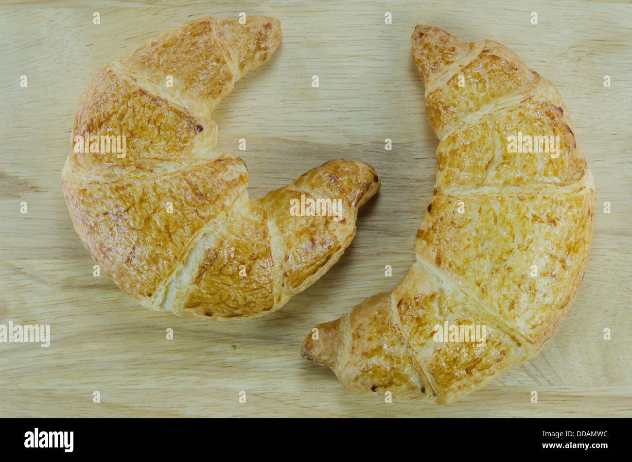 top view two croissants on wooden background Stock Photo - Alamy