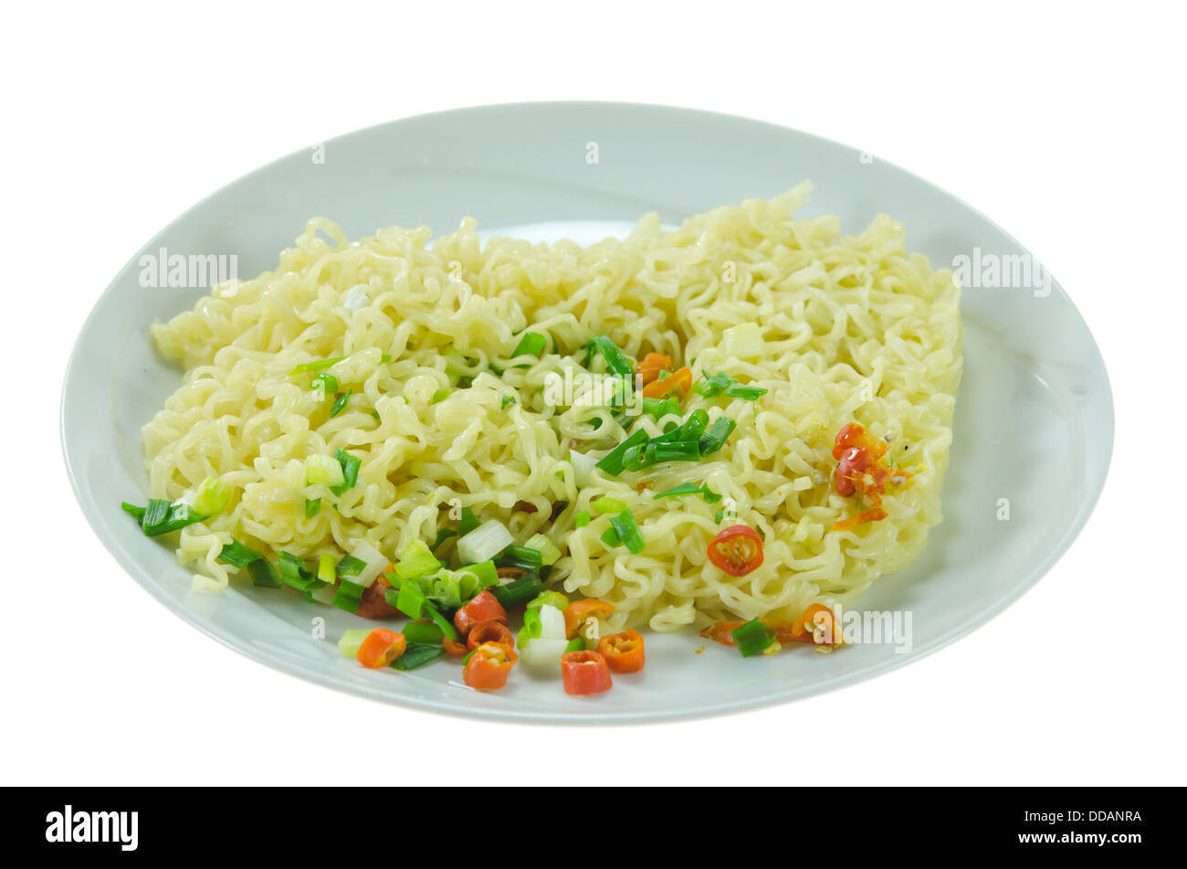 cooked instant noodles with chili and vegetable on dish over white ...